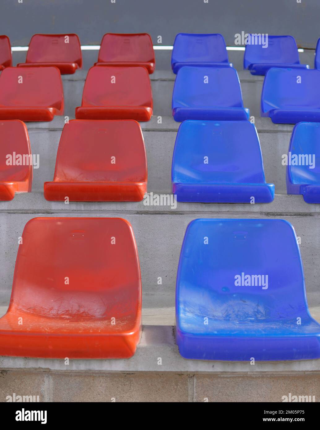 Tier of empty blue and red seats on a soccer field. Seats in the colors ...