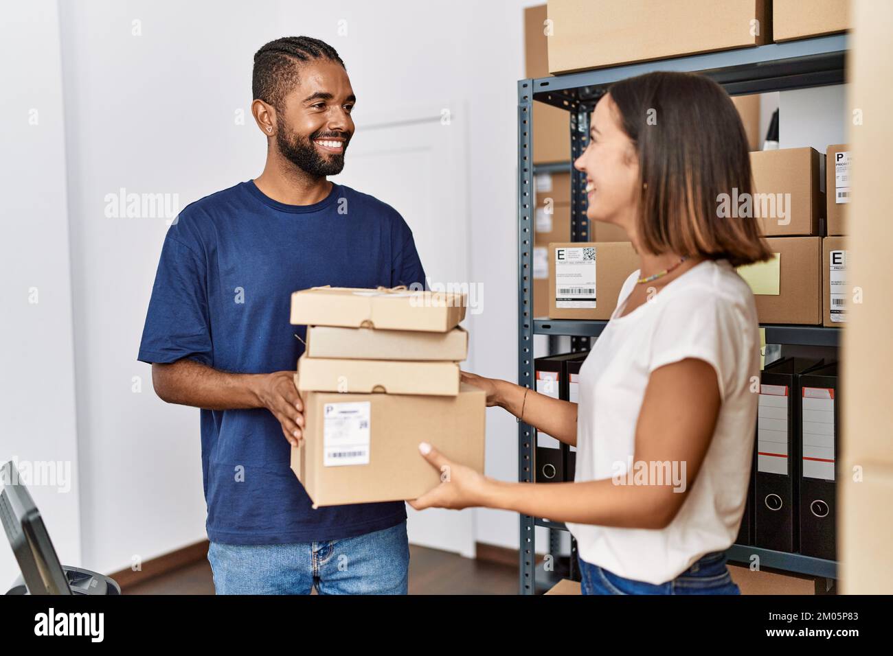 Man and woman business partners smiling confident holding packages at ...