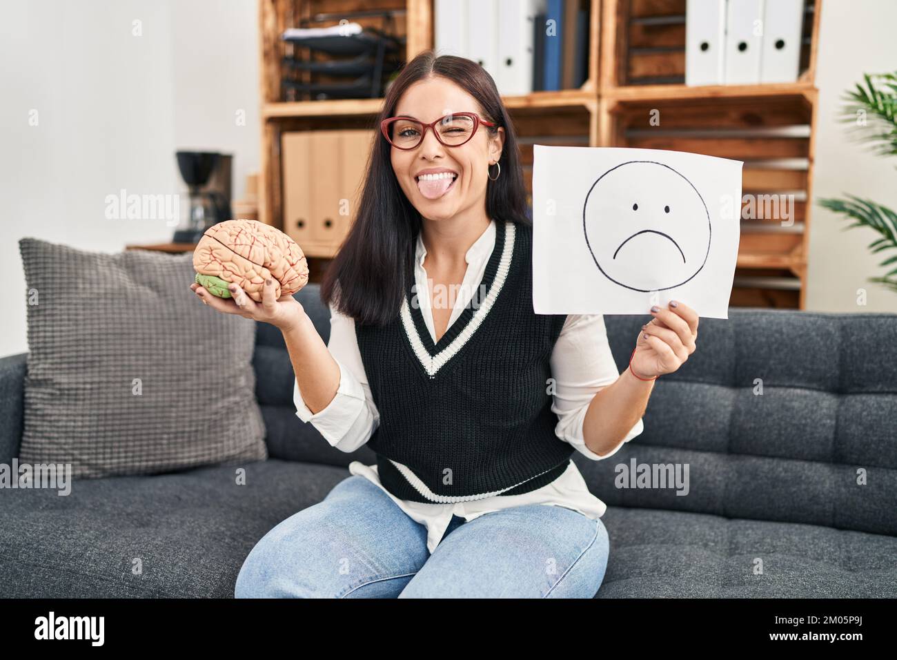 Young hispanic woman working on depression holding sad emotion paper ...