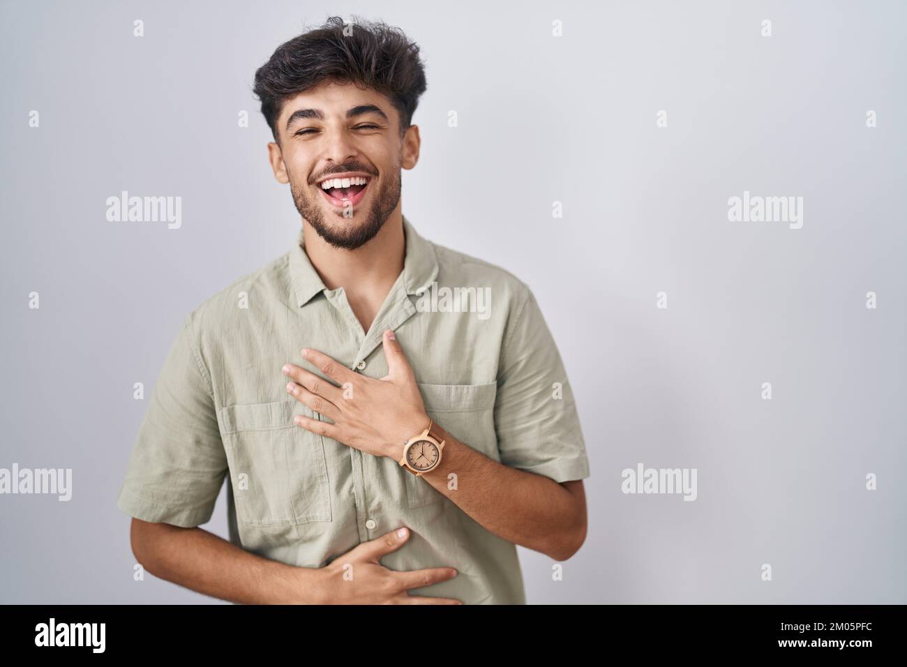 Arab man with beard standing over white background smiling and laughing ...