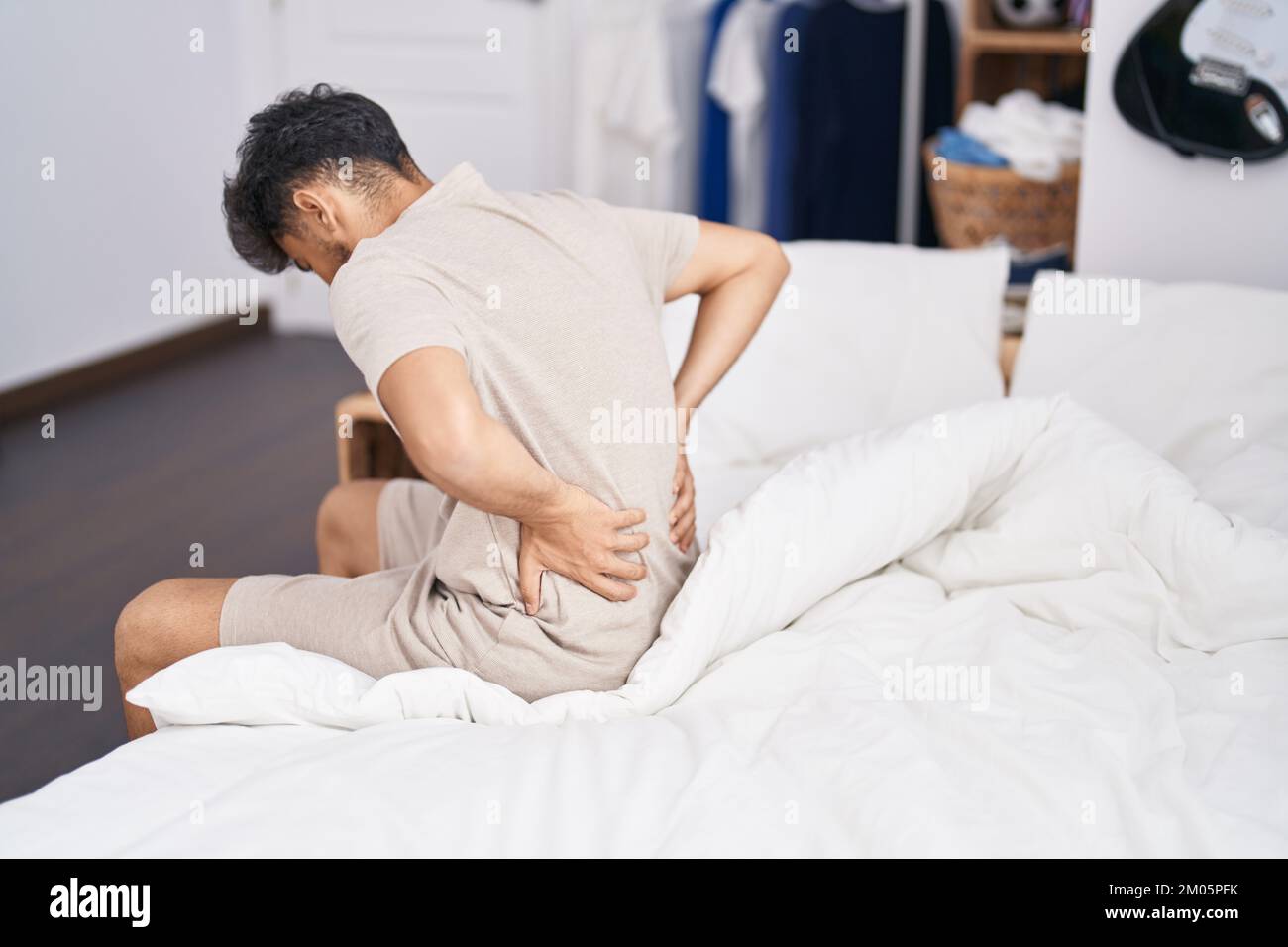 Young arab man suffering for backache sitting on bed at bedroom Stock ...