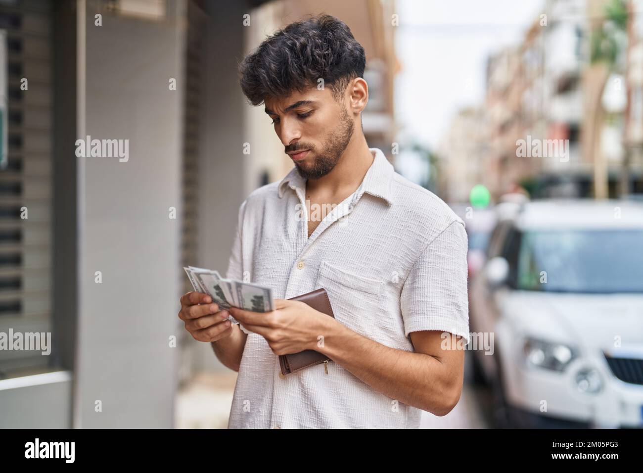 Young arab man counting dollars at street Stock Photo - Alamy