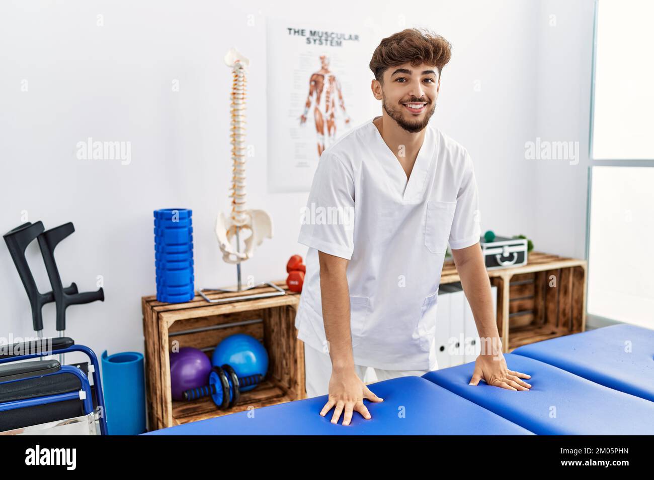 Young arab man wearing physiotherapist uniform standing at clinic Stock ...