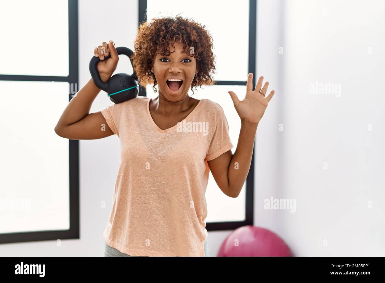 Young african american woman wearing sportswear holding dumbbells ...