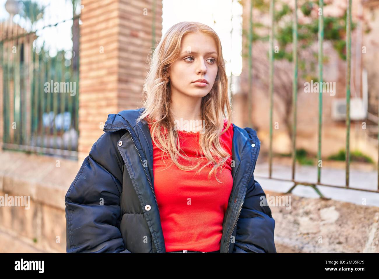 Young blonde woman looking to the side with serious expression at ...