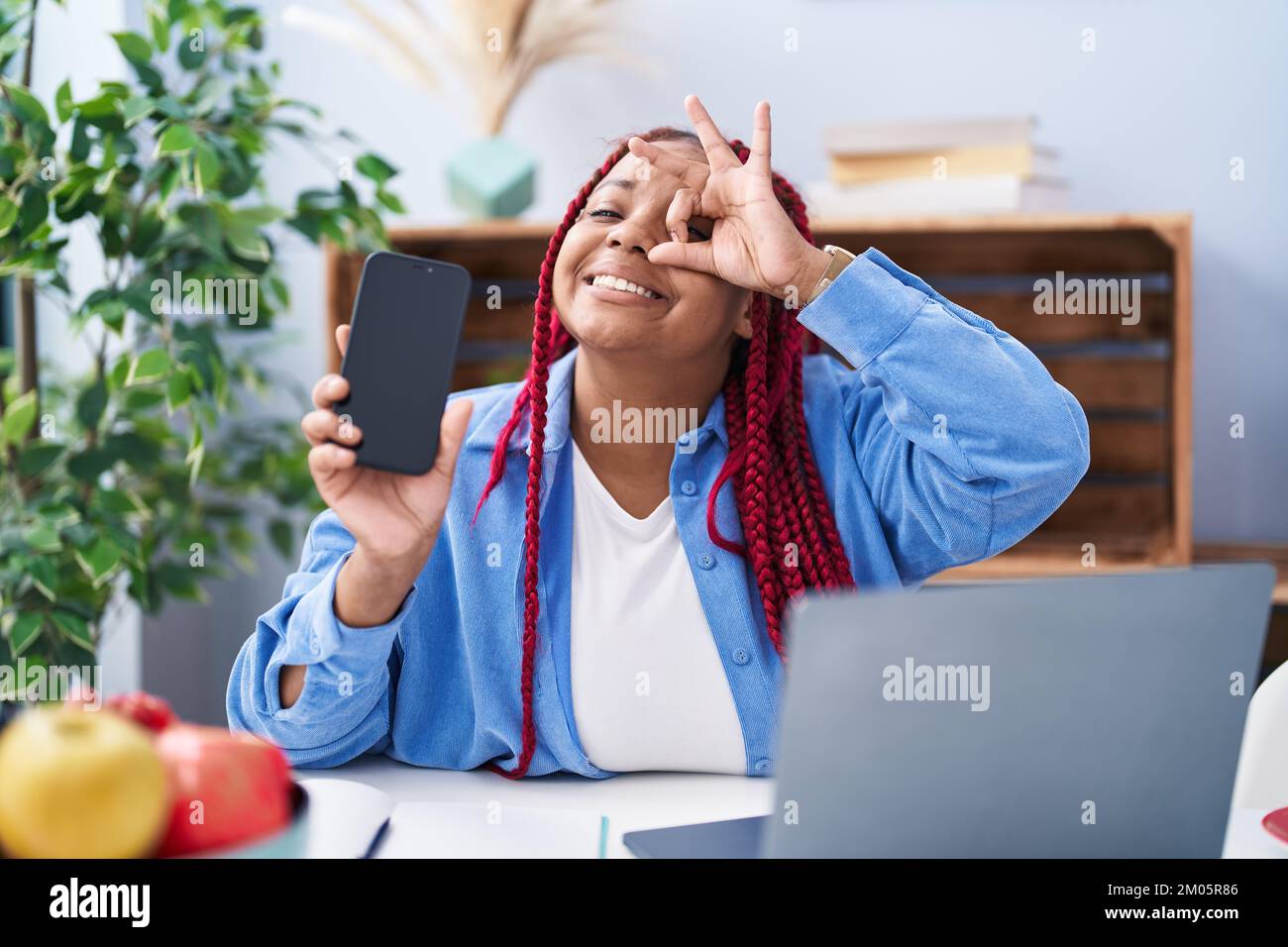 African american woman with braided hair holding smartphone showing ...