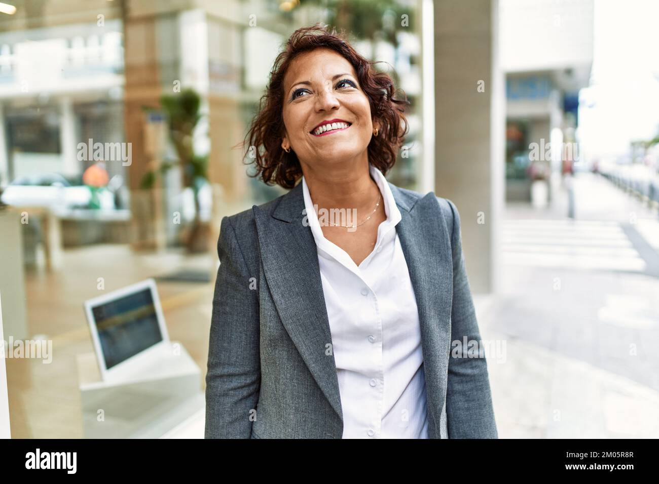 Middle age latin businesswoman smiling happy standing at the city Stock ...