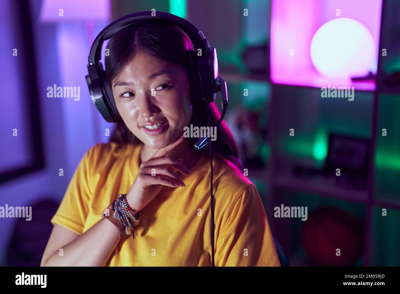 Chinese woman streamer smiling confident using headset at gaming room ...