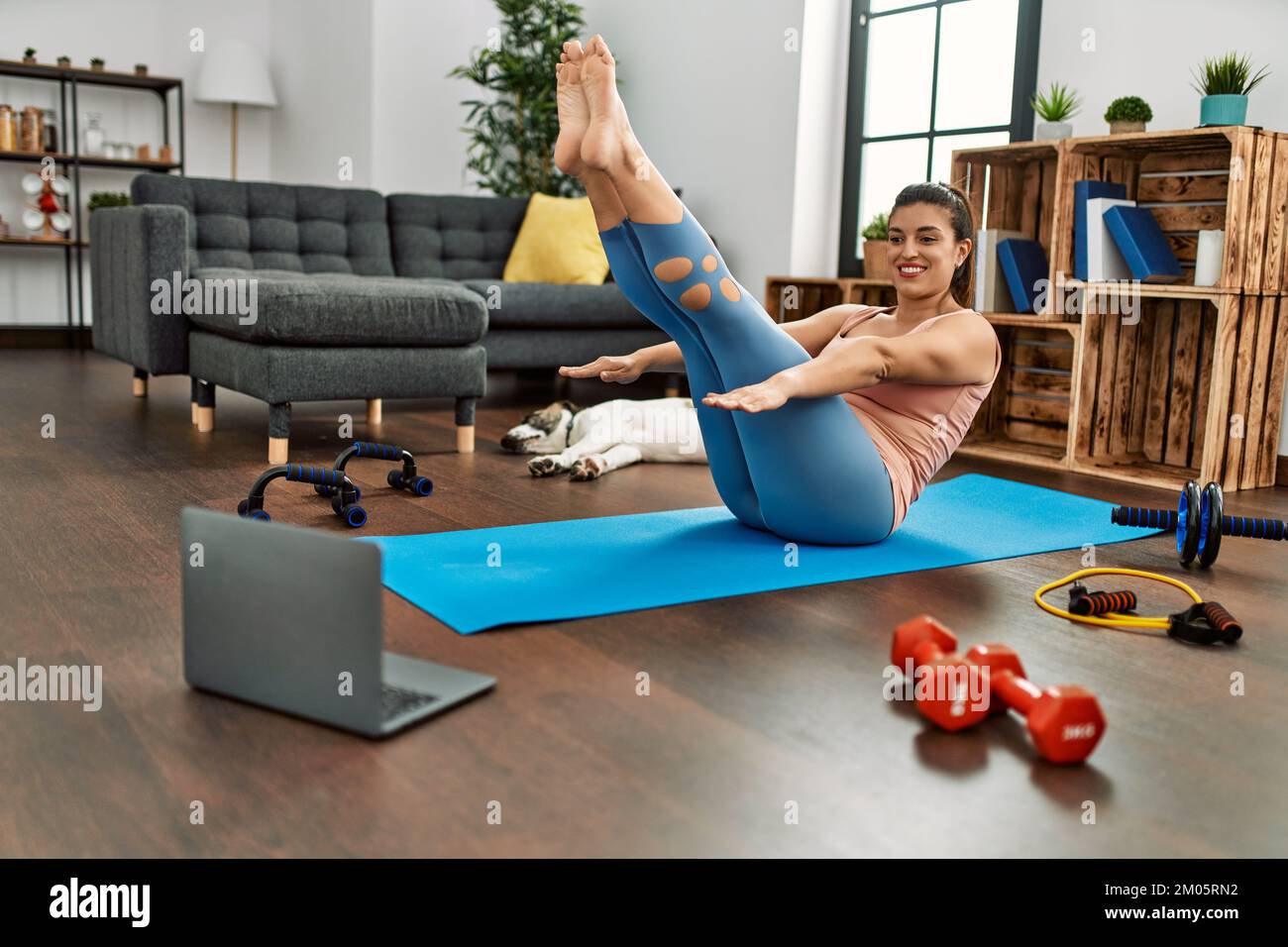Young woman smiling confident having online abs exercise class at home ...