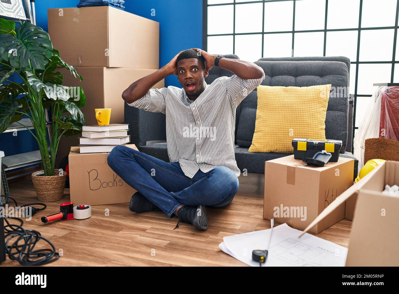 African american man sitting on the floor at new home crazy and scared ...