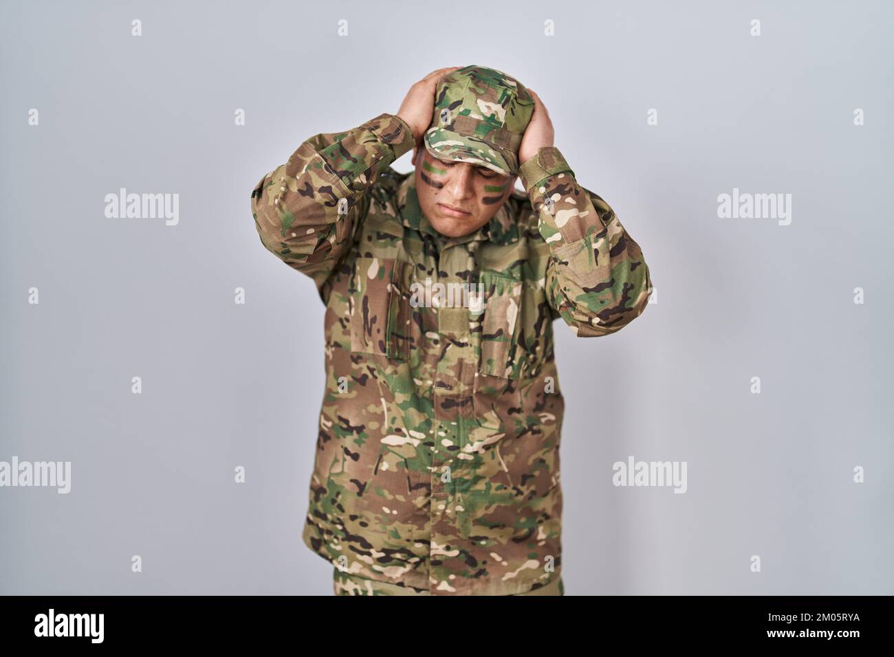Hispanic young man wearing camouflage army uniform suffering from ...