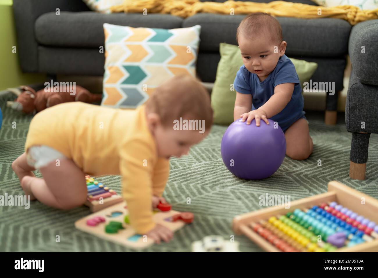 Two toddlers playing with toys sitting on floor at home Stock Photo - Alamy