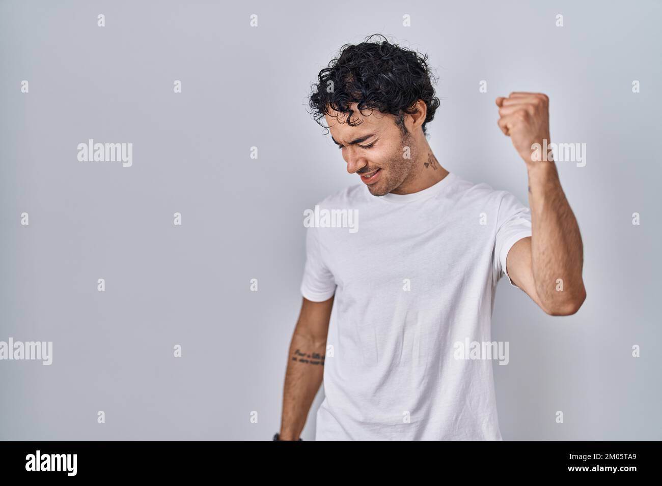 Hispanic man standing over isolated background dancing happy and ...