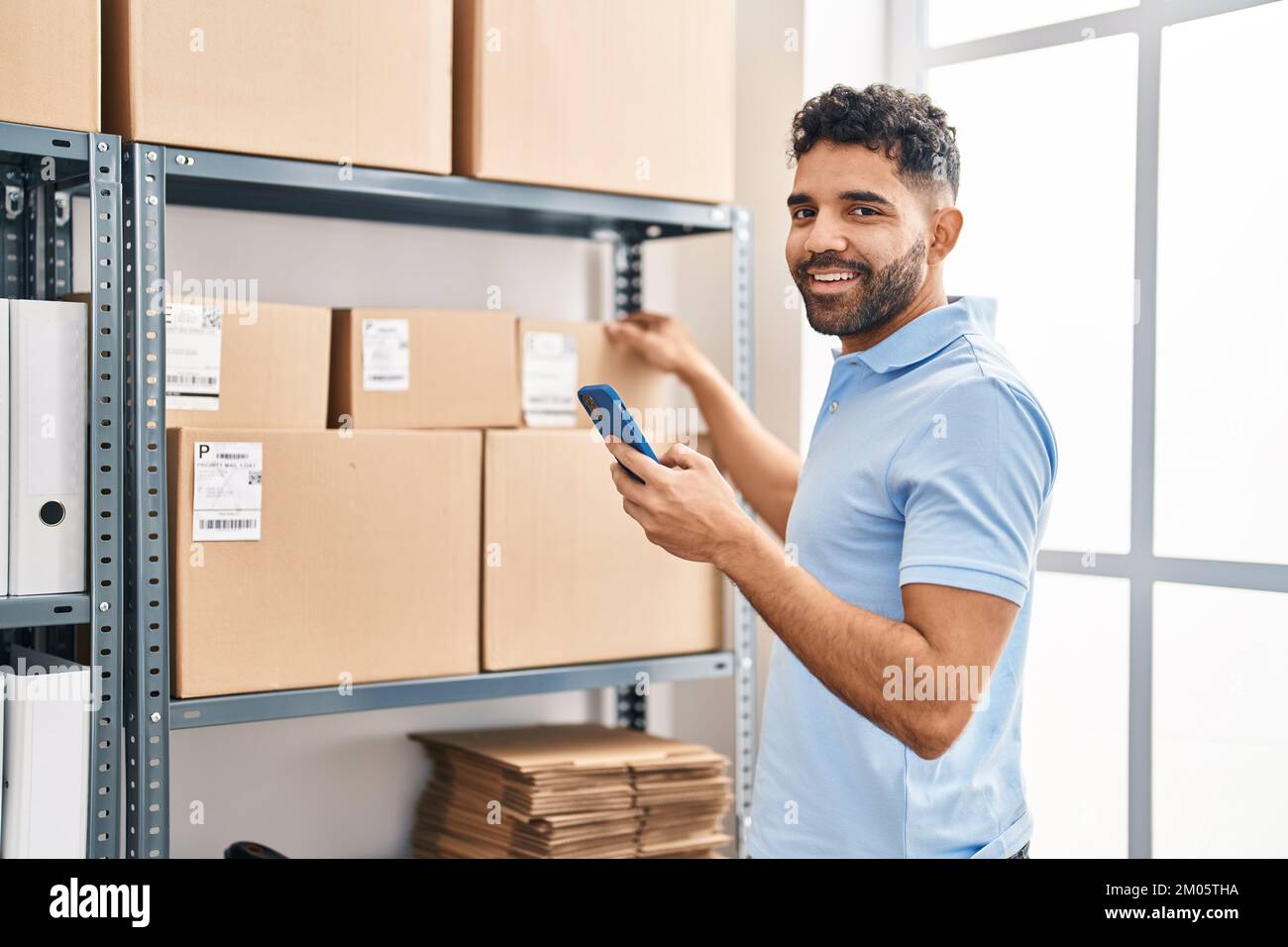 Young hispanic man ecommerce business worker organize packages at ...