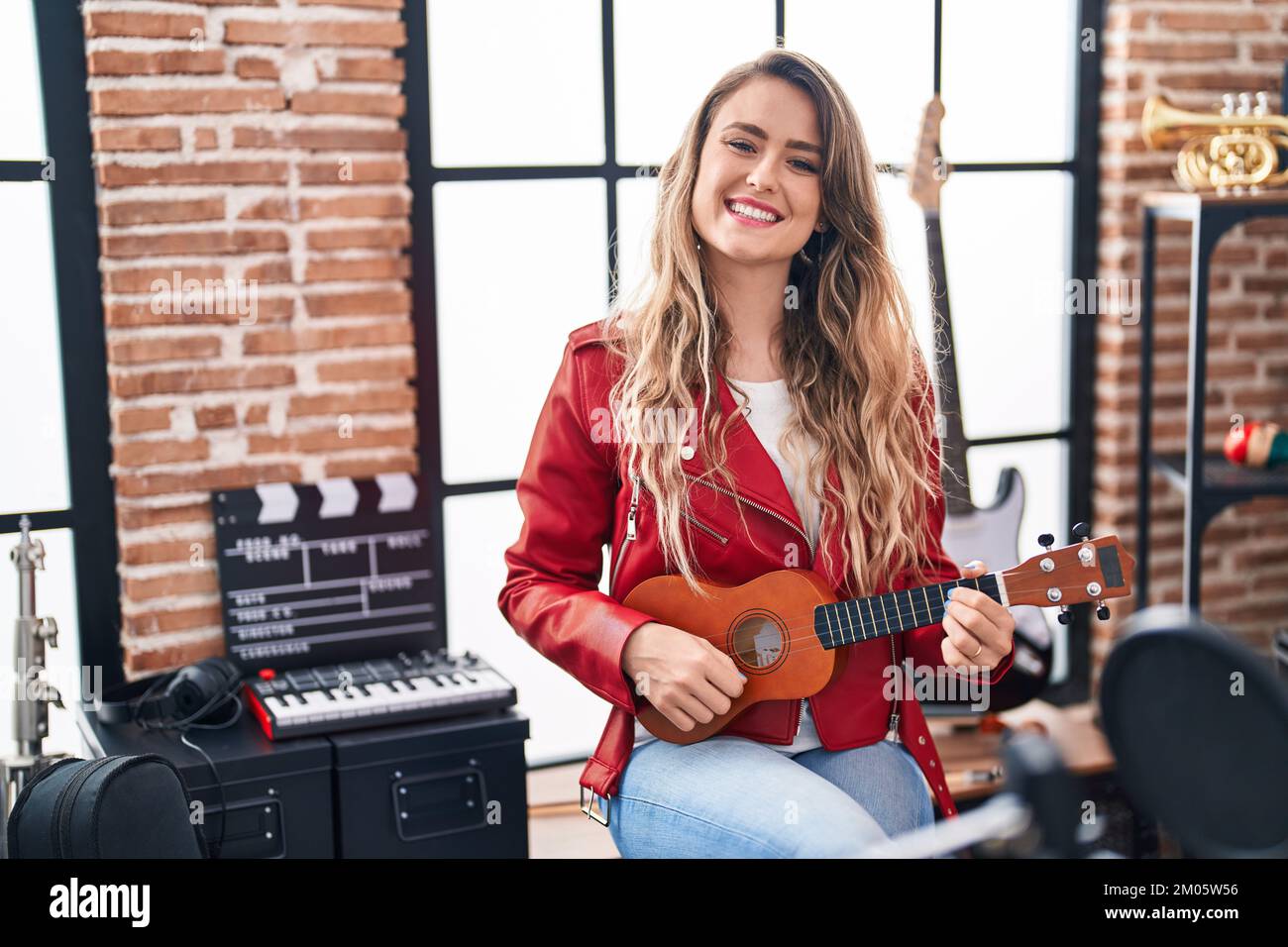 Young woman musician playing ukulele at music studio Stock Photo - Alamy
