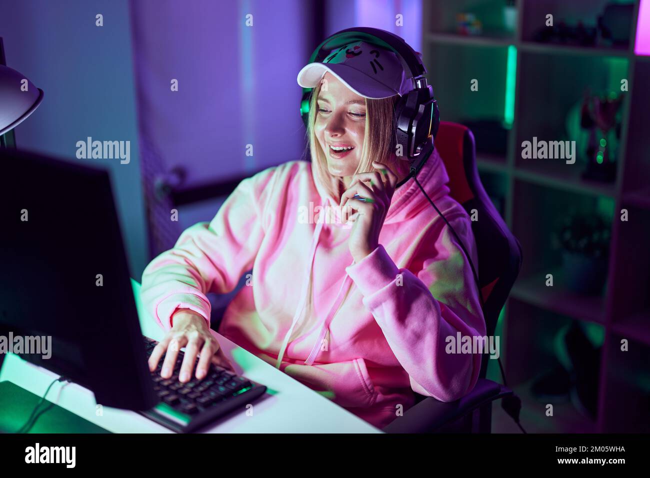 Young blonde woman streamer using computer and headphones at gaming ...