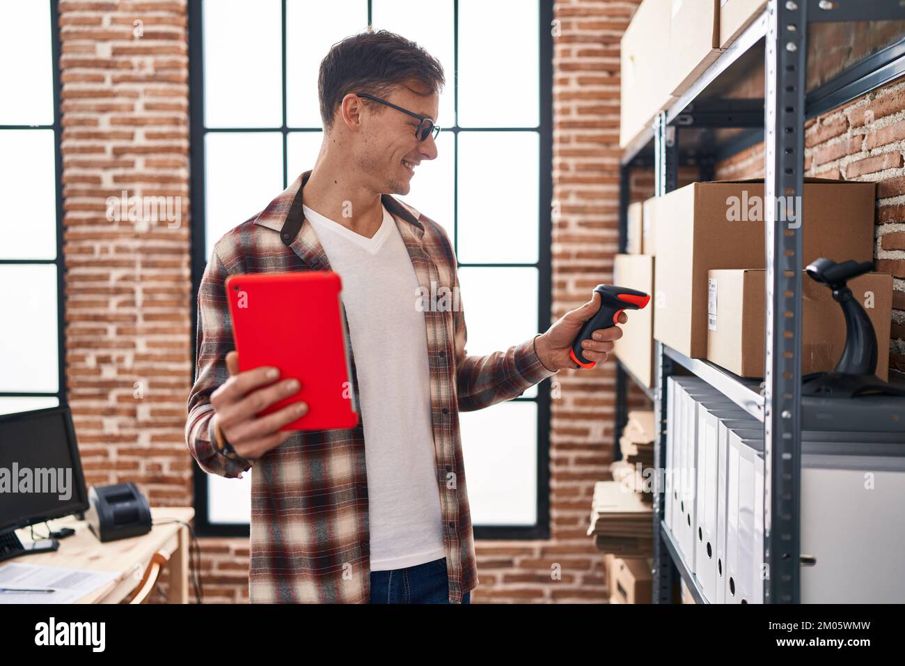 Young man ecommerce business worker scanning package using touchpad at ...