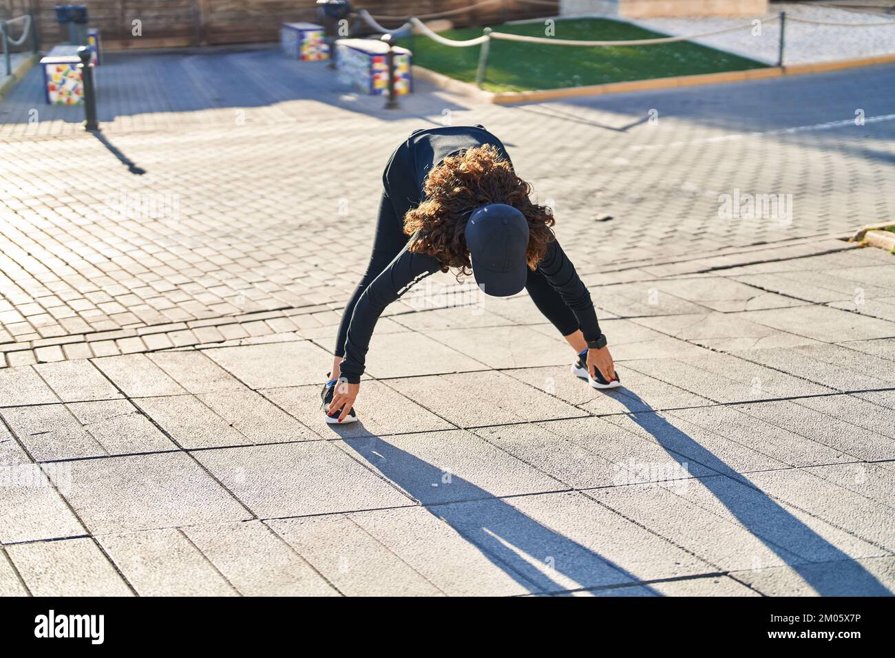 Middle age hispanic woman stretching legs outdoors Stock Photo - Alamy