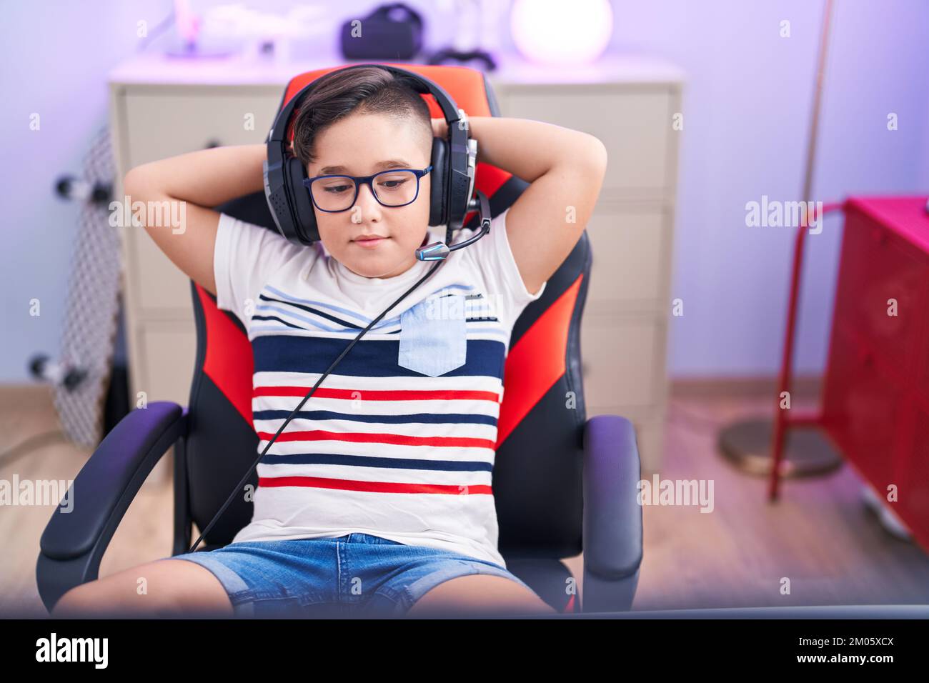 Adorable hispanic boy streamer relaxed with hands on head at gaming ...