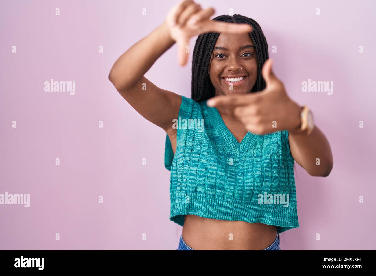 Young african american with braids standing over pink background ...