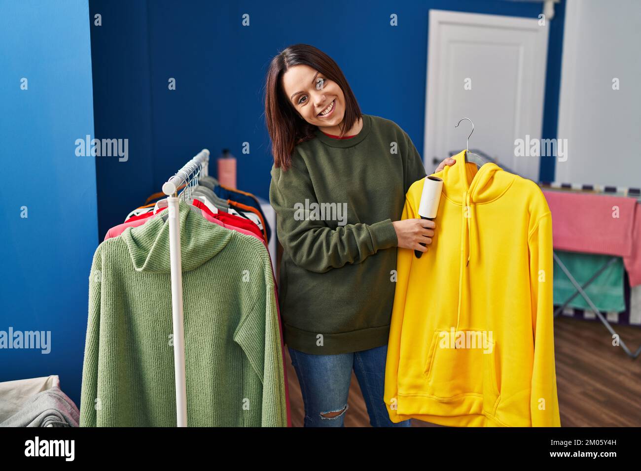 Young beautiful hispanic woman smiling confident cleaning sweatshirt ...