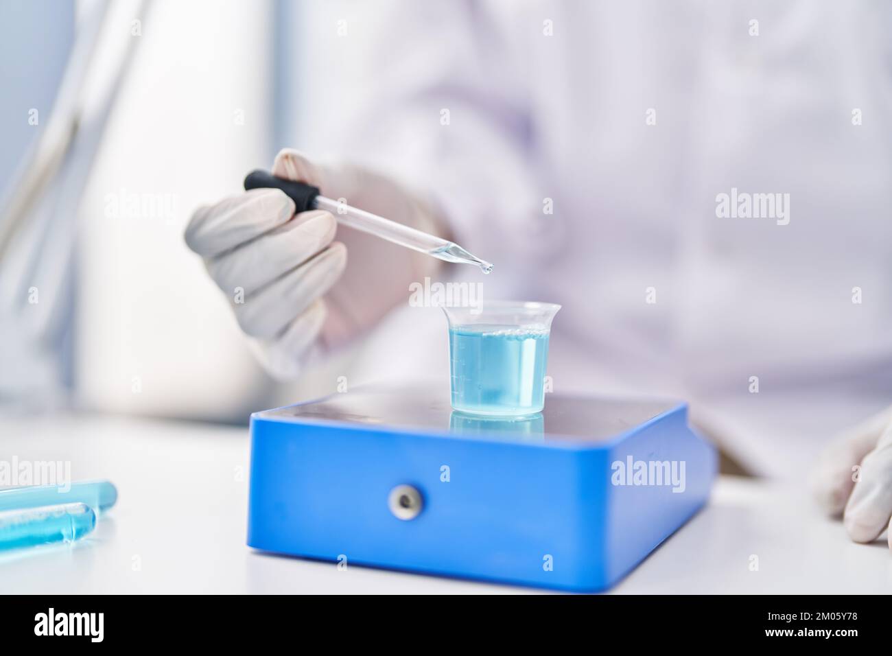 African american woman wearing scientist uniform measuring liquid at ...