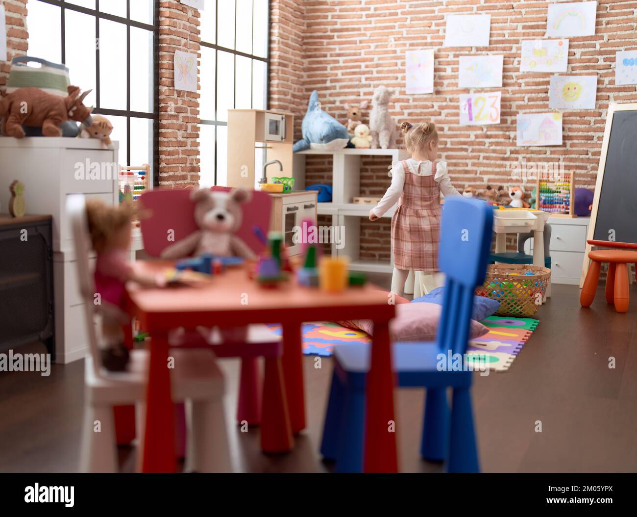 Adorable caucasian girl standing on back view at kindergarten Stock ...