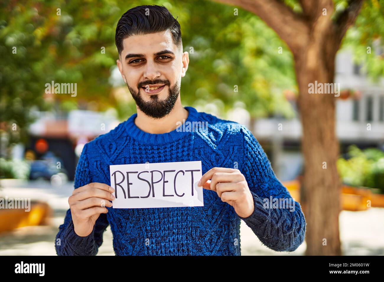 Young arab man smiling confident holding respect banner at park Stock ...