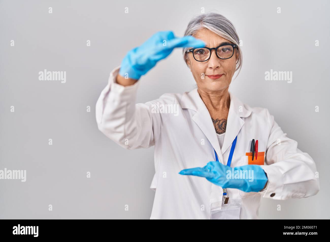 Middle age woman with grey hair wearing scientist robe gesturing with ...
