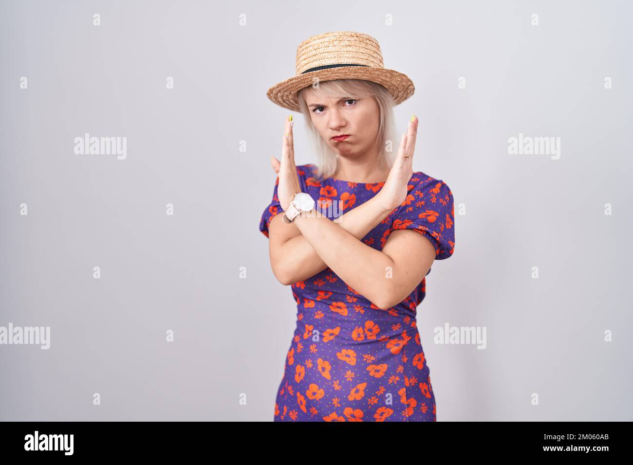 Young caucasian woman wearing flowers dress and summer hat rejection ...