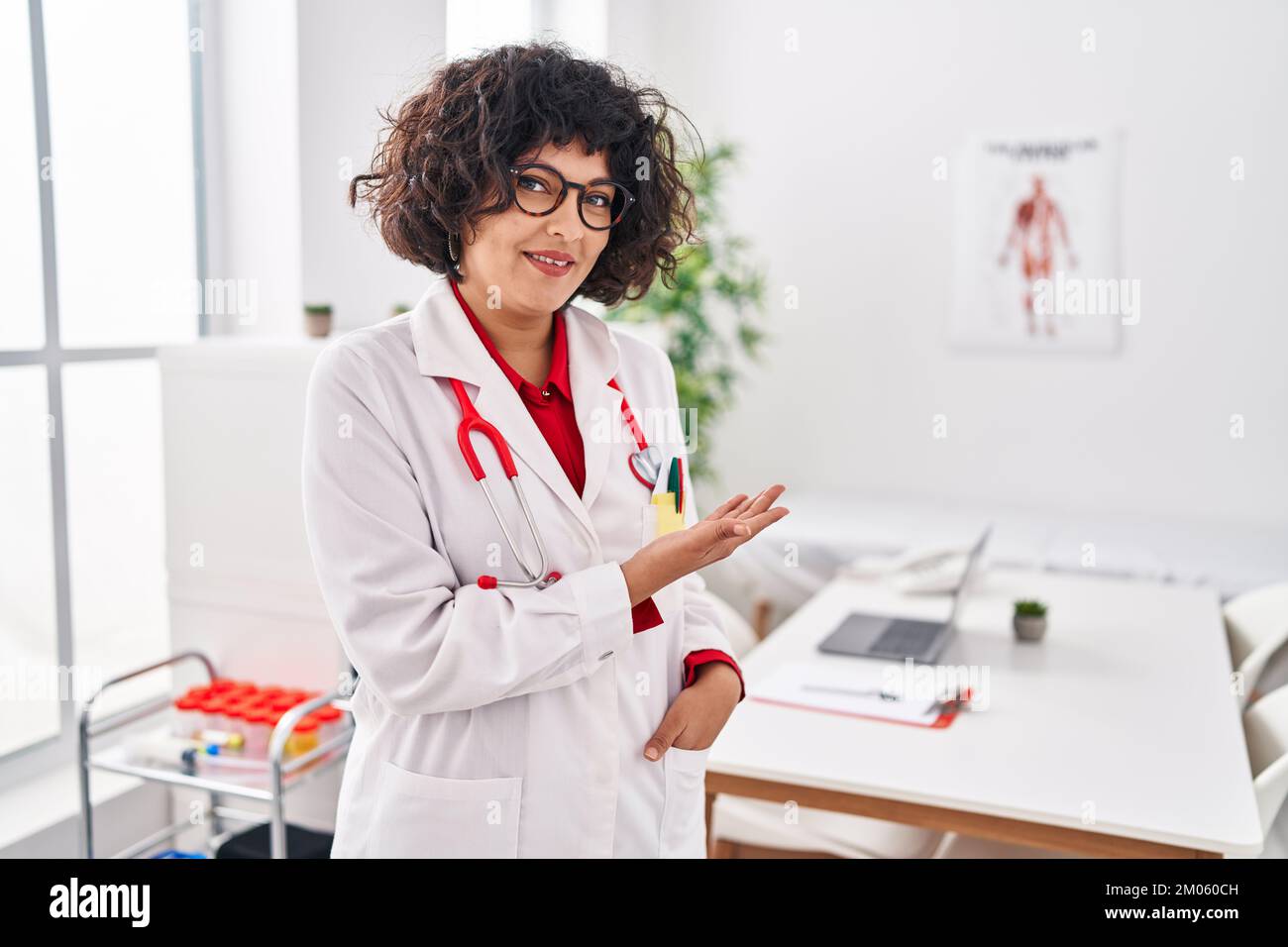 Young beautiful hispanic woman doctor smiling confident standing doing ...