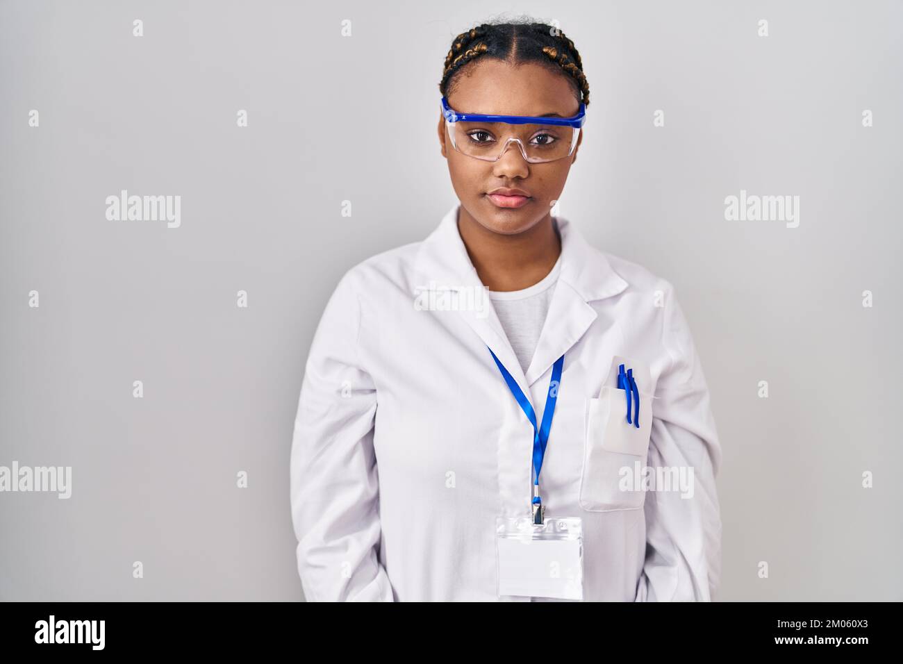 African american woman with braids wearing scientist robe with serious ...