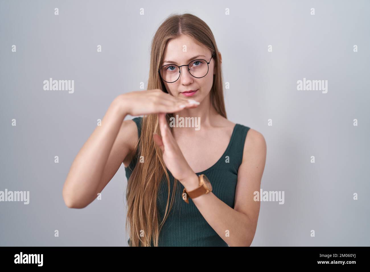 Young caucasian woman standing over white background doing time out ...