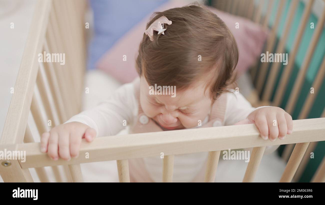 Adorable toddler standing on cradle crying at bedroom Stock Photo - Alamy