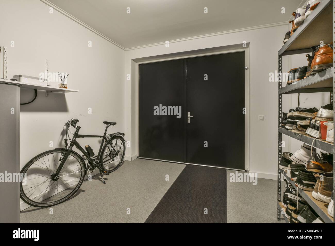 Spacious garage with closed door and white walls with hangers on it ...