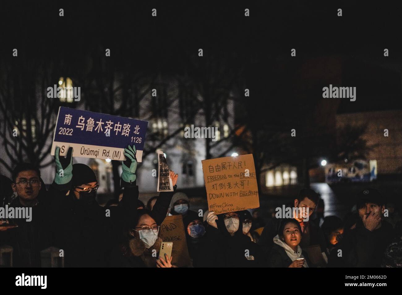 A protester seen holding the "Urumqi Middle Road" street sign that ...