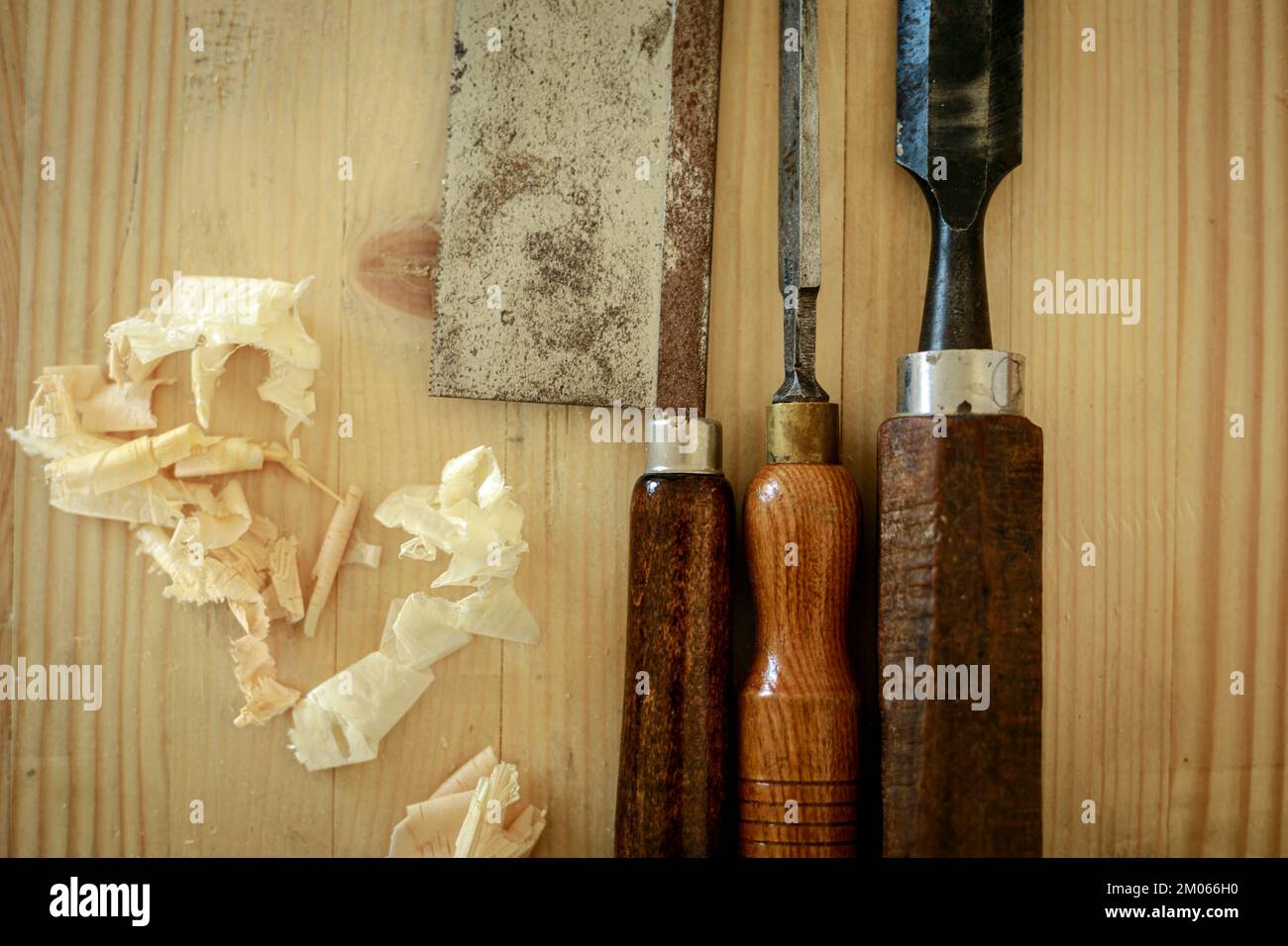 Traditional carpenter's tools on light wooden table; a saw and two ...
