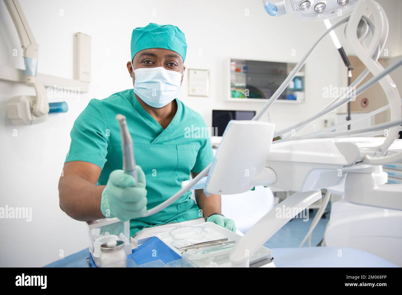 Tooth doctor in the clinic with a dental drill in his hand and wearing ...