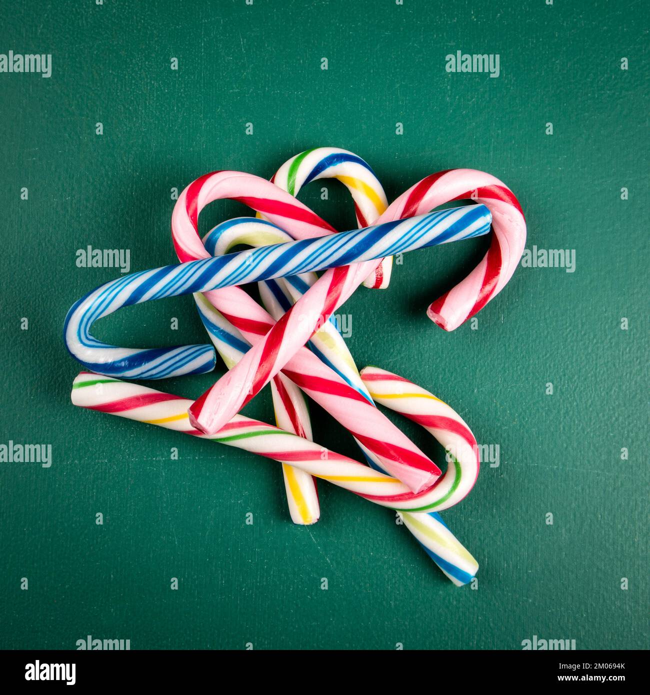 Colorful candy canes in a pile on a green chalkboard background Stock ...