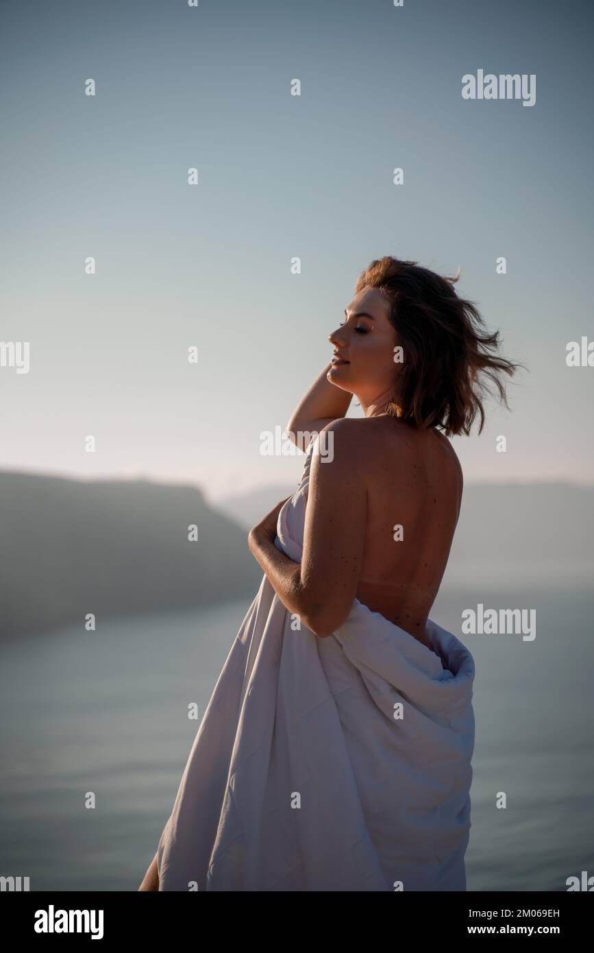 Woman wake up in bed wuth duvet and pillow over nature sea background ...