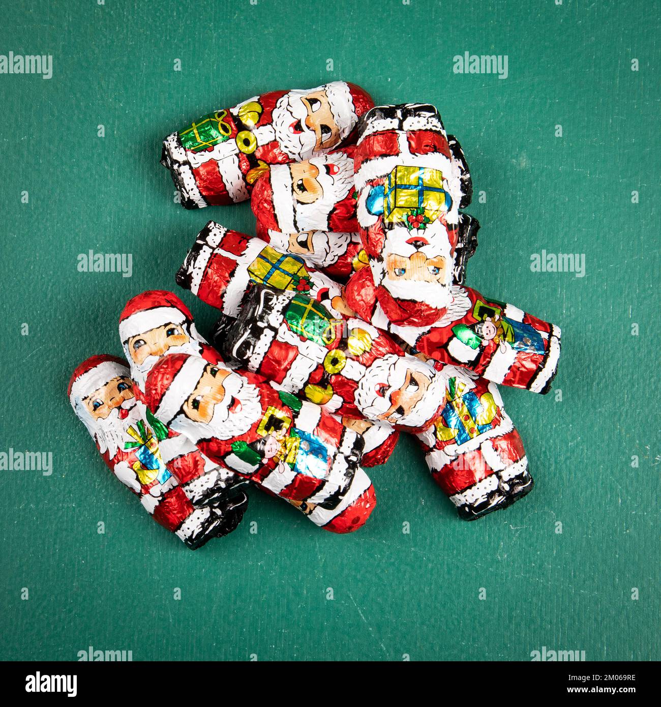 Chocolate Santa candies on a green chalkboard background. Winter season ...