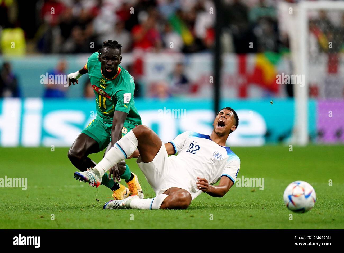 England's Jude Bellingham, (right) is tackled by Senegal's Pathe Ciss ...