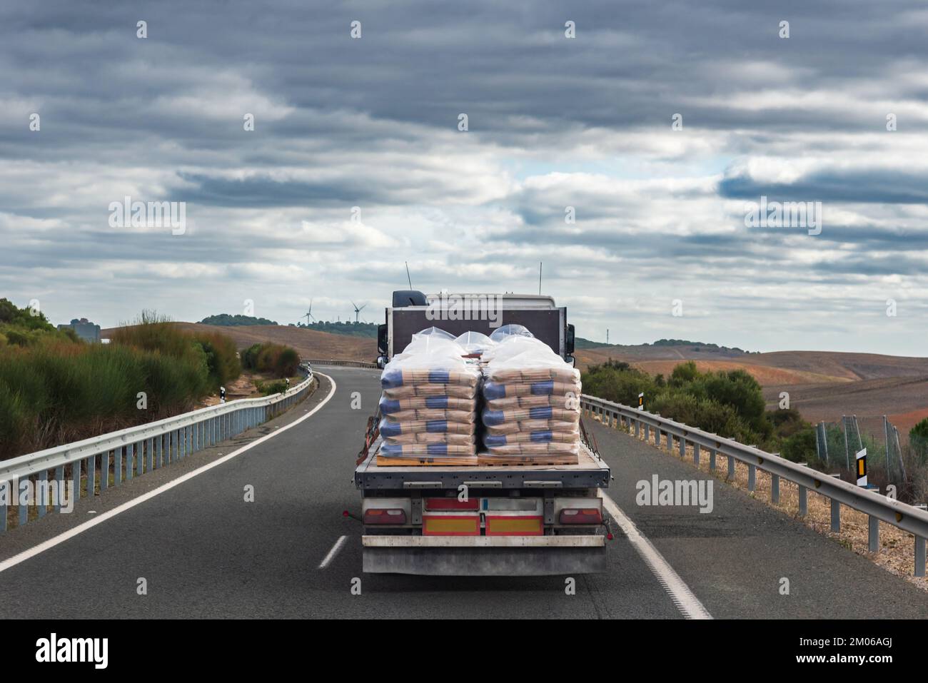 Truck loaded with bags of cement driving on a highway Stock Photo - Alamy