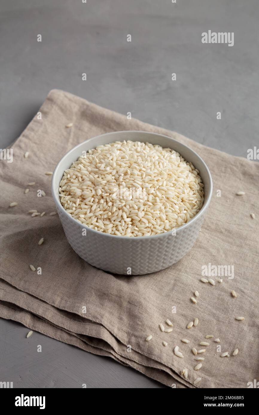 Raw Organic Carnaroli Rice in a Bowl on a gray surface, side view Stock ...