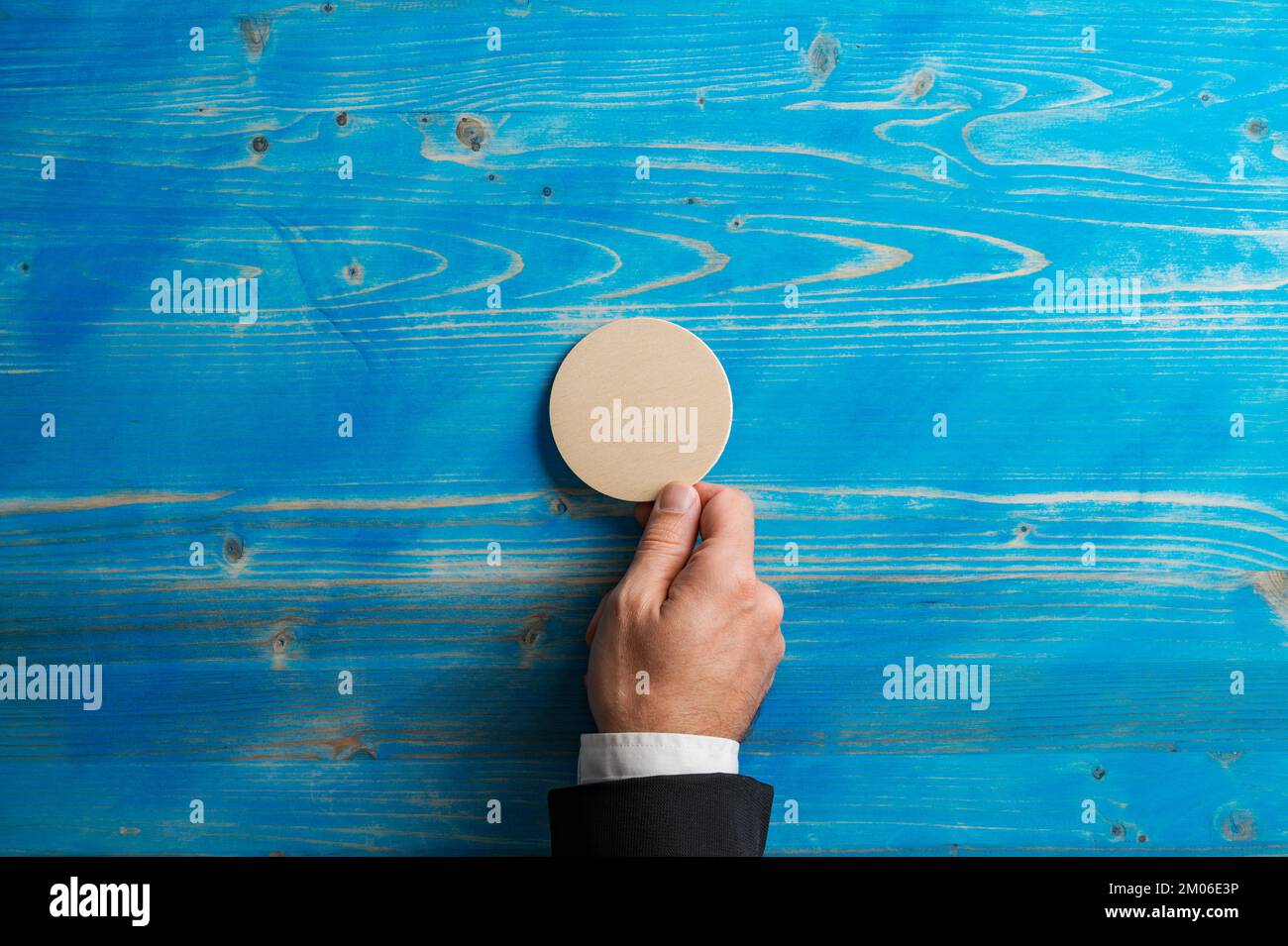 Top view of hand of a businessman placing blank simple wooden cut ... Top view of hand of a businessman placing blank simple wooden cut ...