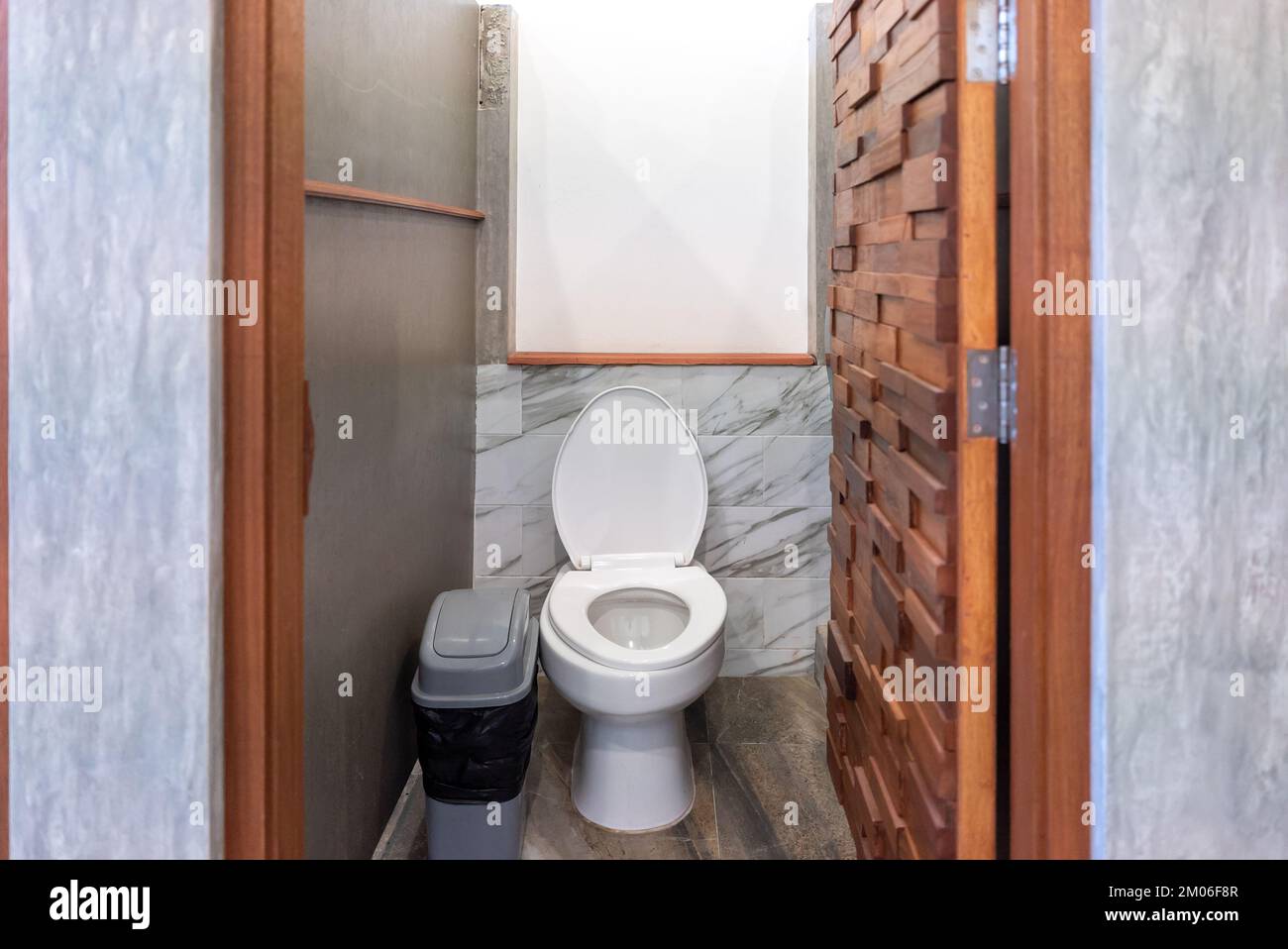 Bathroom with beautiful toilet and wood door Stock Photo - Alamy