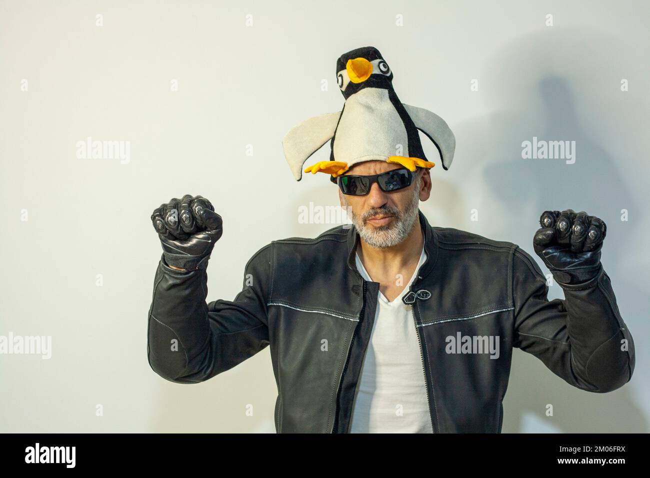 man dressed as a biker with a jacket and leather gloves with a penguin ...