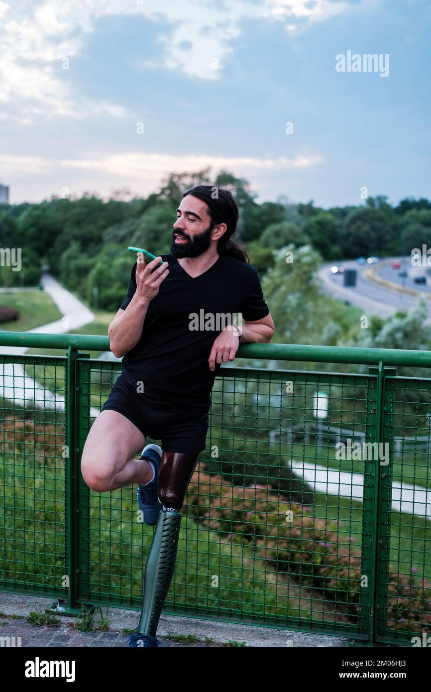 Young man with a prosthetic leg enjoying an afternoon outdoors while ...