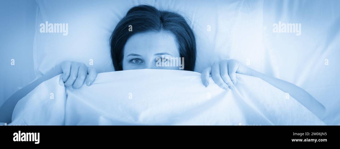 Panorama of young sad woman in bed, blue tone Stock Photo - Alamy