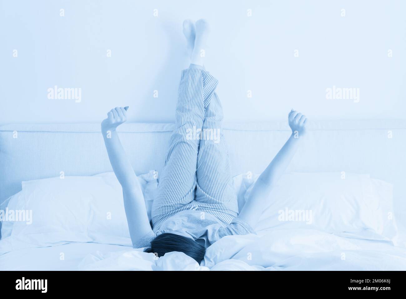 Girl with legs up lying on bed in bedroom Stock Photo - Alamy